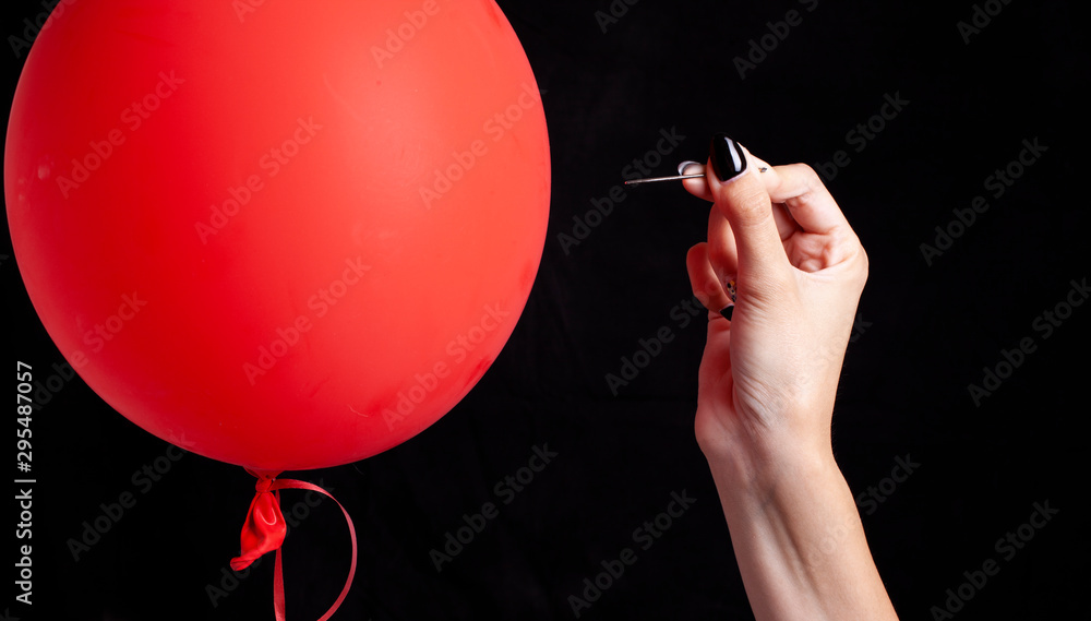 burst red balloon with a needle - danger concept Stock Photo | Adobe Stock
