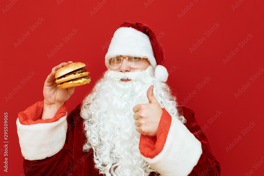 Portrait of happy Santa Claus on red background with burger in hand ...