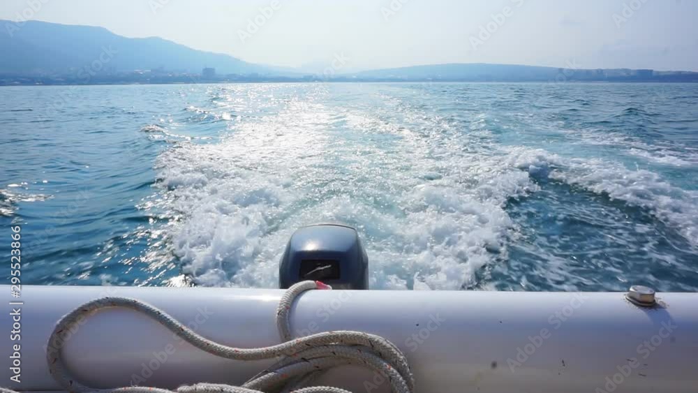 Outboard motor creates waves on the surface of the ocean. Trace of ...