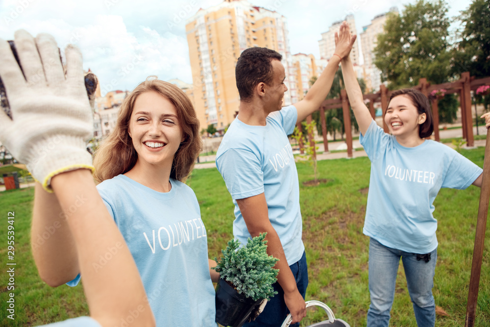 Volunteering. Young people volunteers outdoors planting trees giving ...