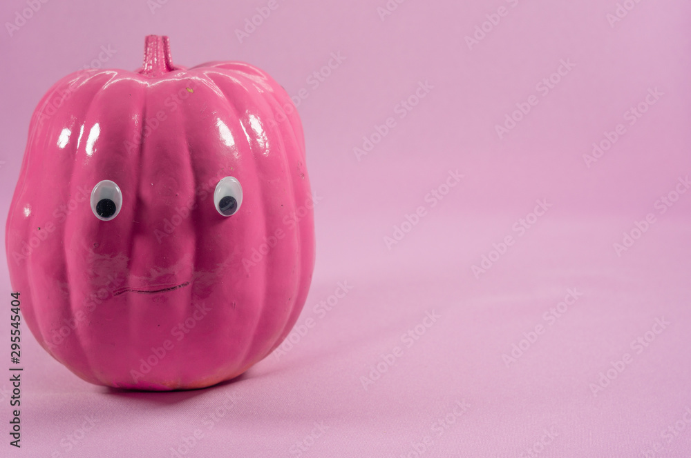 Cute pink pumpkin with googly eyes on pastel pink background with ...