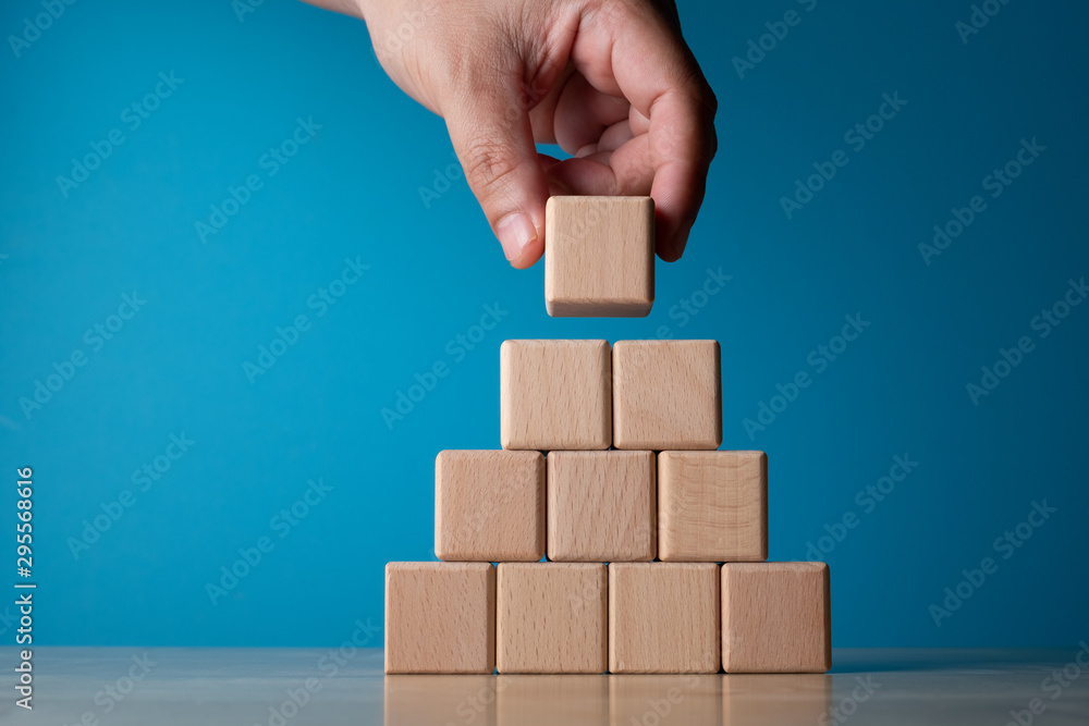 Hand arranging block on blue background. Business concept on progress ...