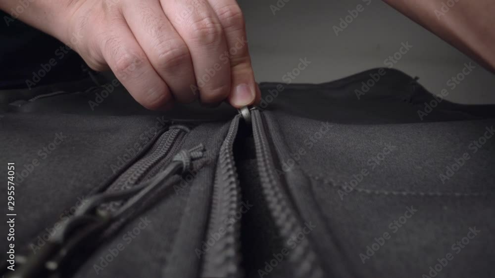 Extreme close up zipper with hand unzipping the sweater jacket zipper ...