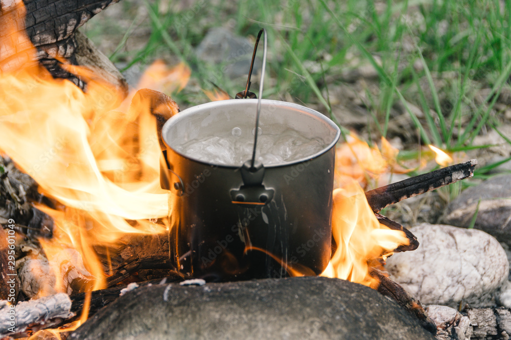 Tourist pot over the fire. Cooking in aluminum cookware. Survival in ...