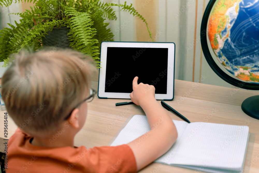 a young boy in glasses shows a finger at the black blank screen of the ...