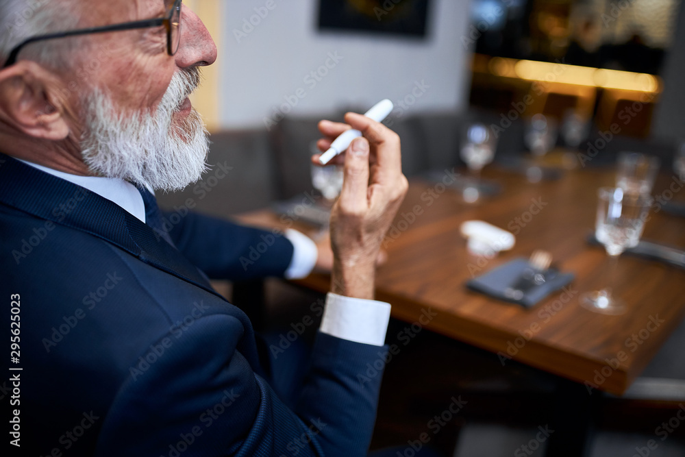 Elderly man vaping in closed public space. Smoking electronic cigarette ...