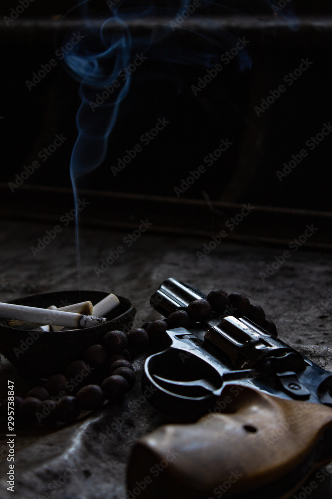 Revolver and rosary. Revolver and rosary with an ashtray. Stock Photo ...