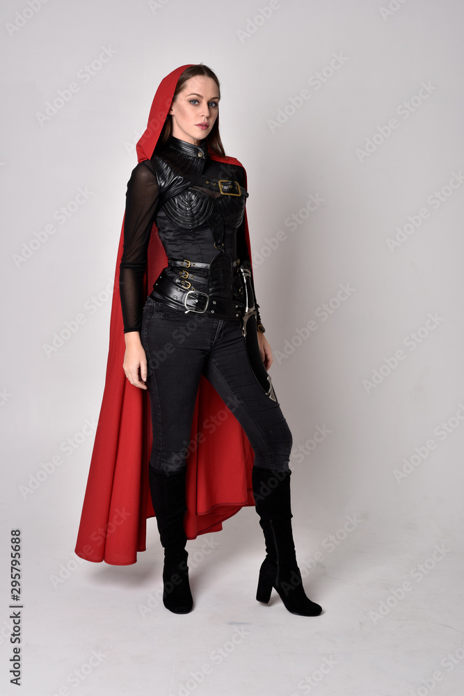 full length portrait of a pretty brunette woman wearing black leather ...