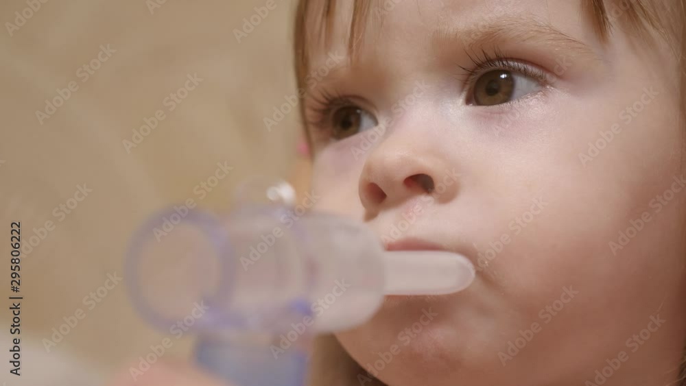 child is sick and breathes through an inhaler. Toddler treats flu by ...
