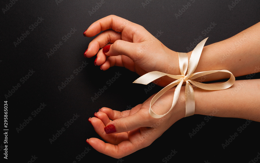 Beautiful female hands tied on a black background. Top view with place ...