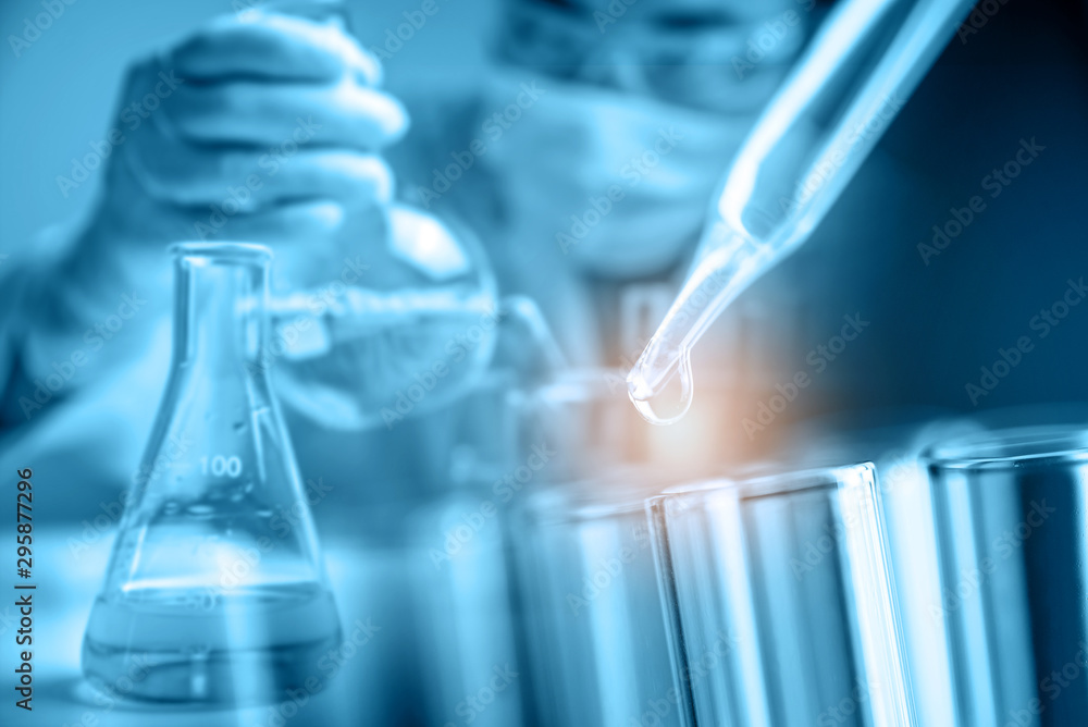 Scientist testing some chemical sample at laboratory with lab glassware ...