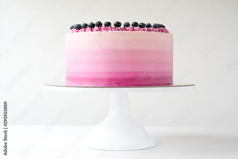 Birthday cake with blueberries and purple gradient cream on white ...