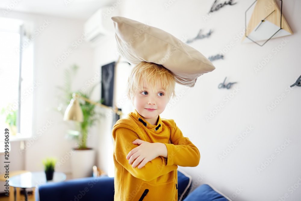 Pillow fight. Mischievous preschooler child jumping on a sofa and ...