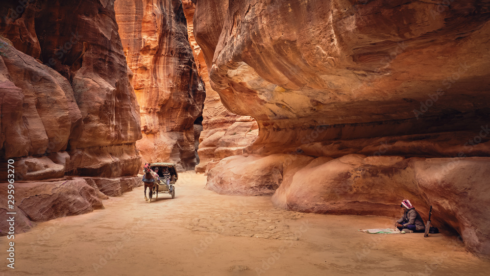 The Siq with a horse-drawn cart for transporting tourists and a rababa ...