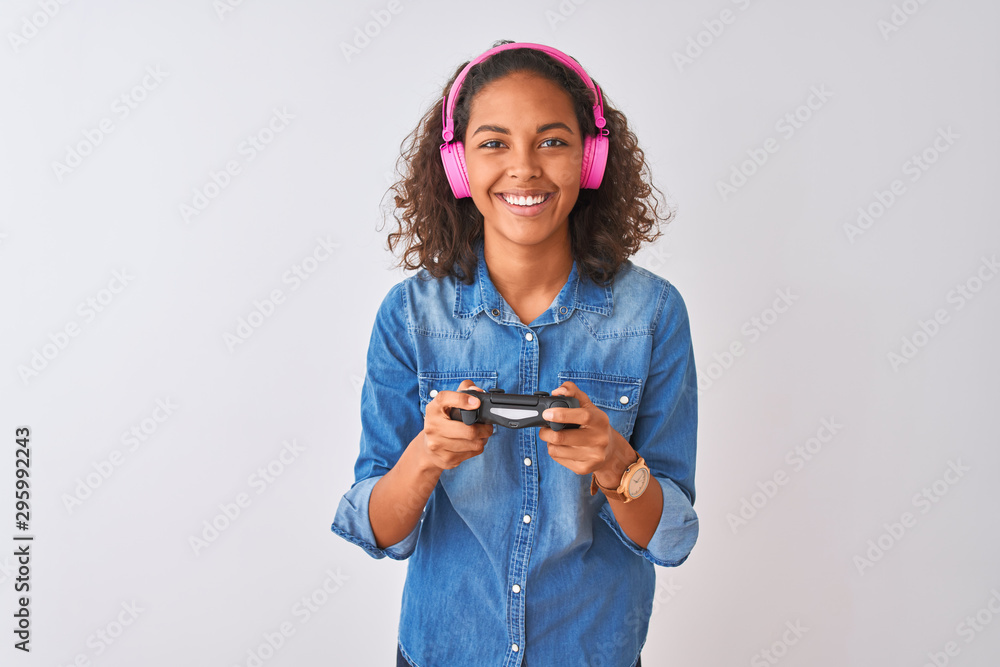 Brazilian gamer woman playing video game using headphones over isolated ...