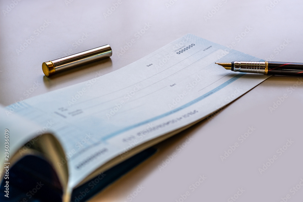 Cheque book and fountain pen isolated on office desk. Paycheck and ...
