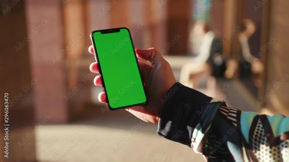 Close up man hand using phone with vertical green screen background ...