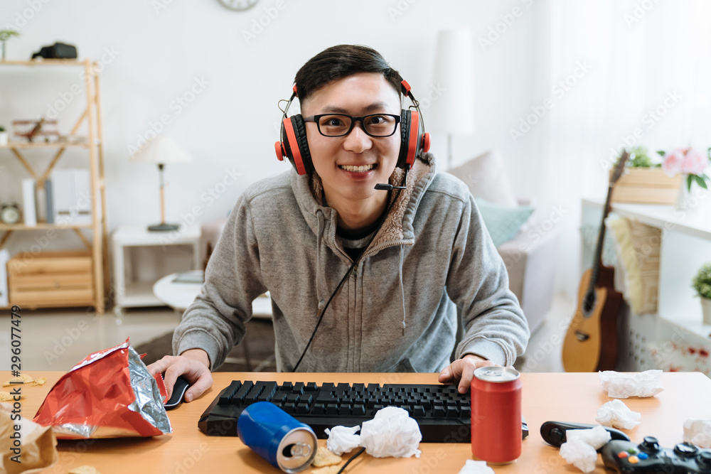 Foto de Focused male gamer smiling looking at game and using computer ...