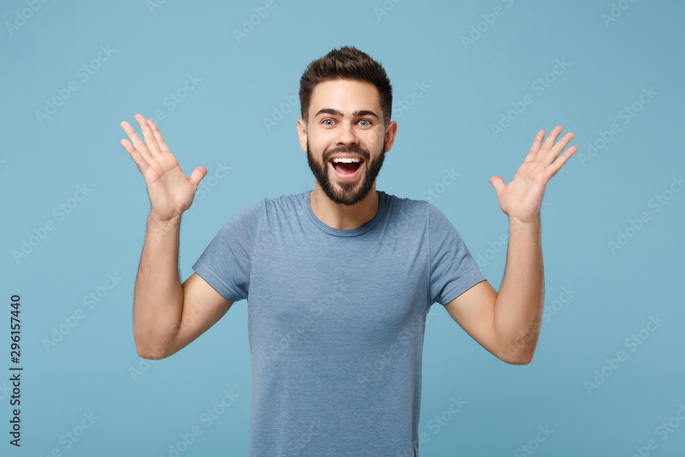 Young excited handsome man in casual clothes posing isolated on blue ...