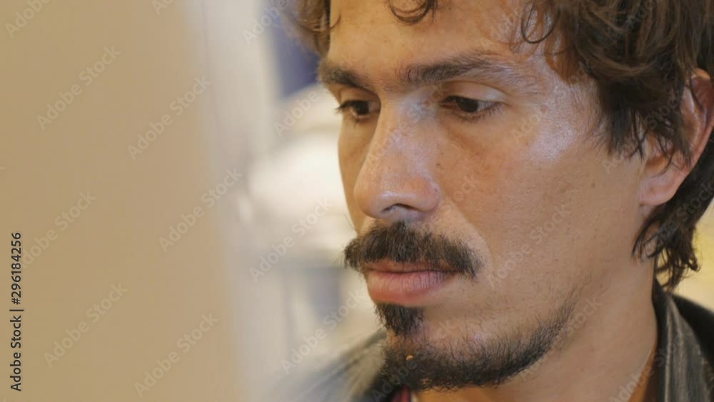 Male hispanic artist with mustache and beard paints oil still-life ...