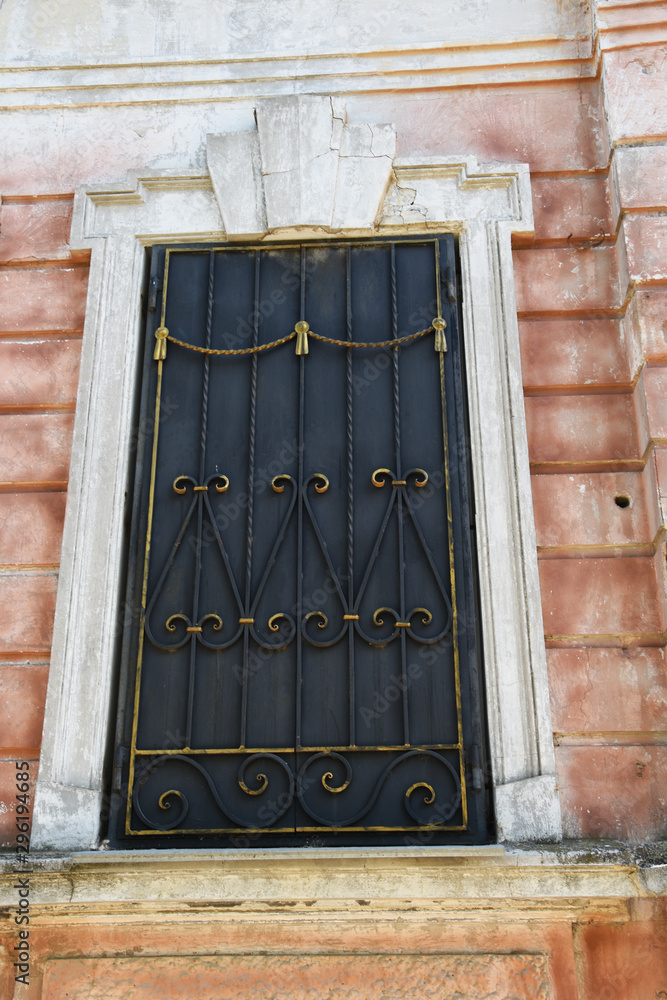 The window of the old house is closed with wooden shutters and chained ...