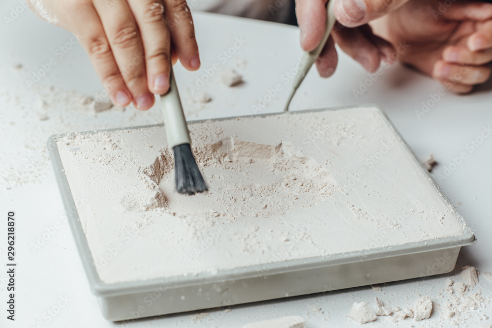 Foto Stock A child plays an archaeologist excavated. Hands close up ...