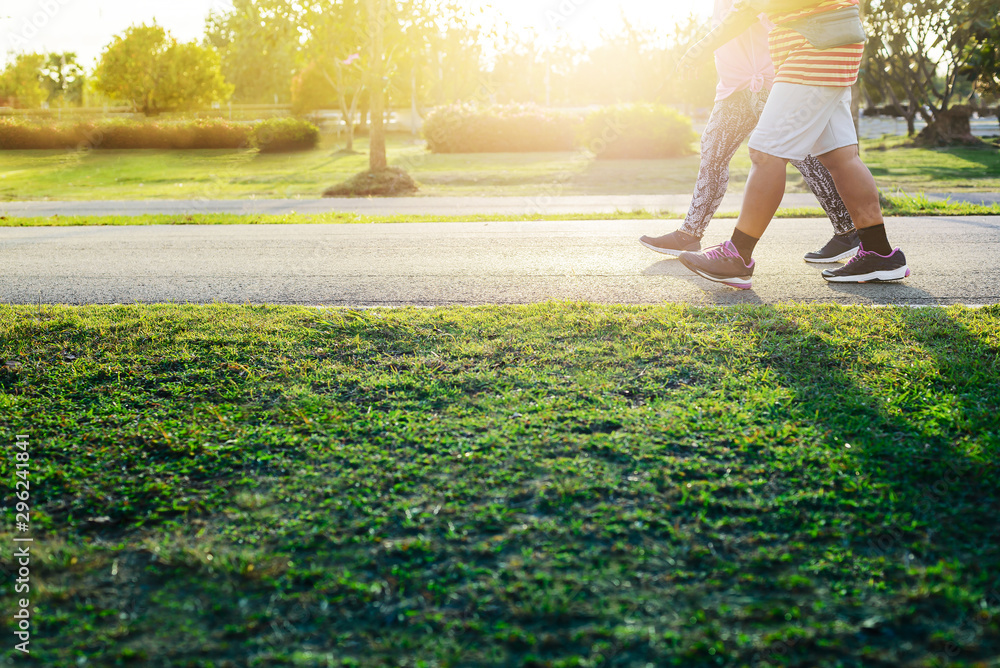 The picture focuses on the legs of two people walking and exercising ...
