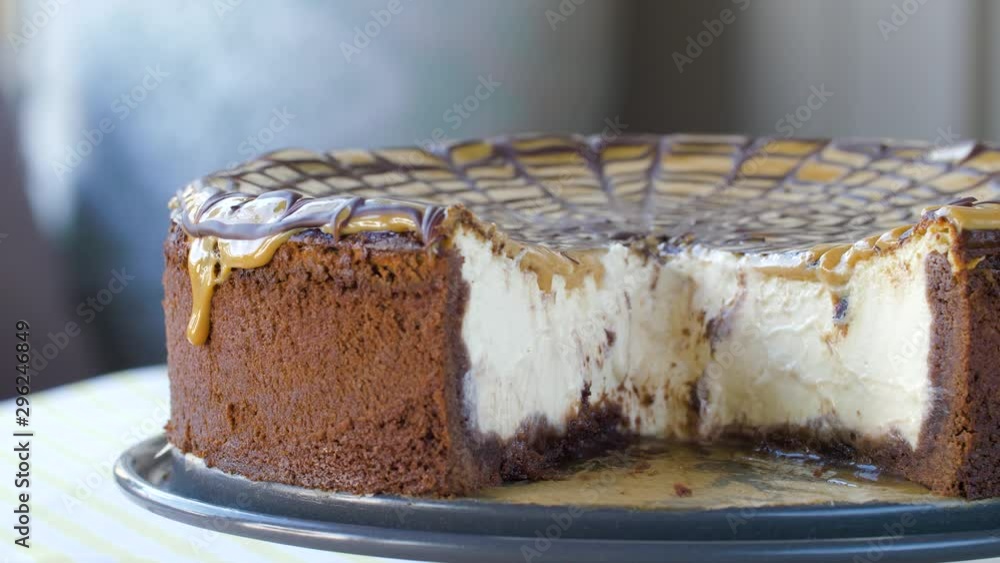 Cheesecake topped with melted salted caramel and chocolate cobweb. One ...