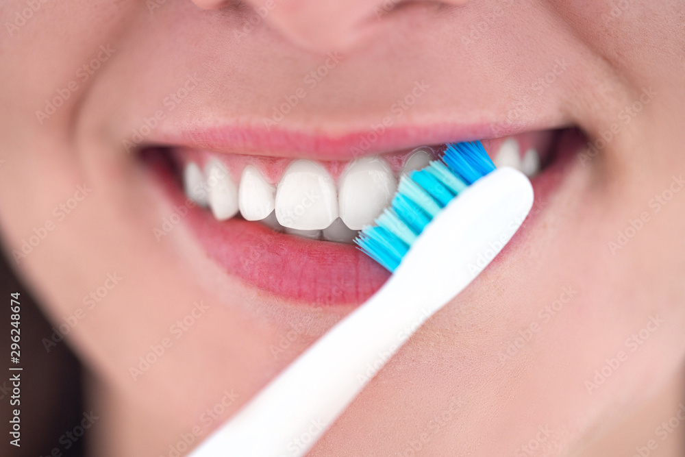 Brushing teeth with ultrasonic electric toothbrush close-up. Dental ...