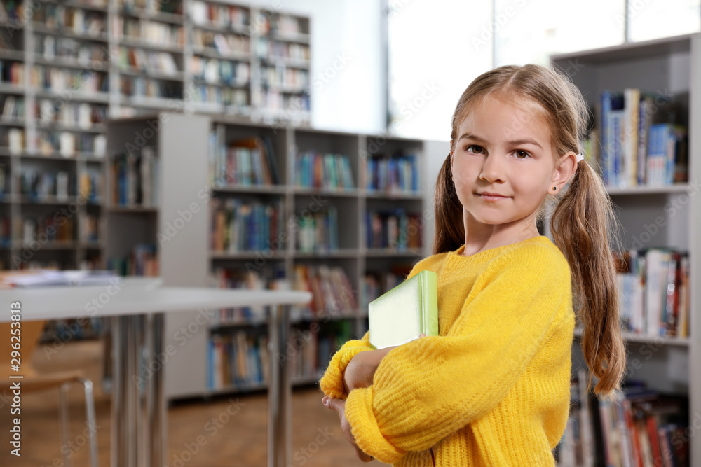 Cute little girl with books in library reading room Stock Photo | Adobe ...