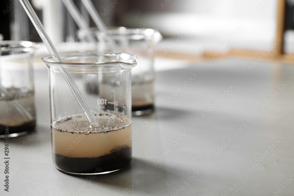 Foto de Beaker with soil extract on light table, space for text ...