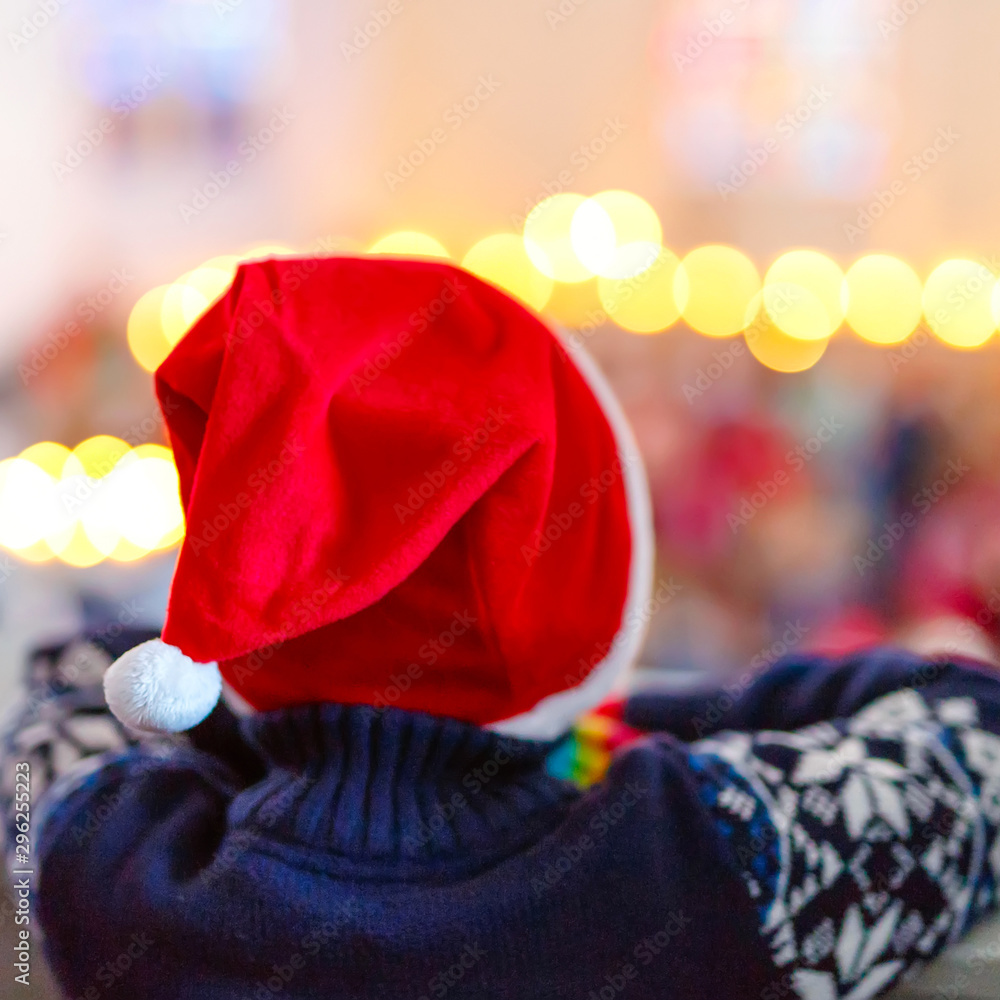 Cute little child on Christmas in a church. Praying kid boy with lights ...