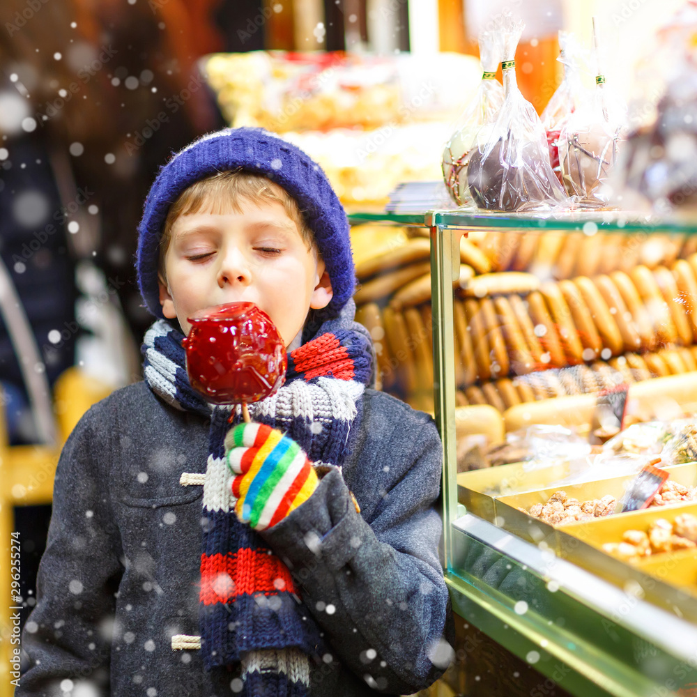 Little cute kid boy near sweet stand with gingerbread and nuts. Happy ...