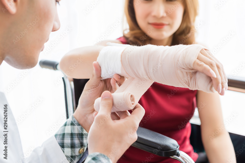 Close-up of man doctor with wrapping nurse bandages splint to the arm ...