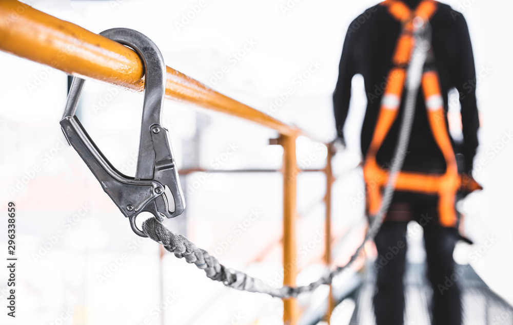 Construction worker wearing safety harness and safety line working at ...