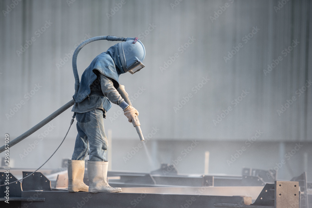 Sand blasting process, Industial worker using sand blasting process ...