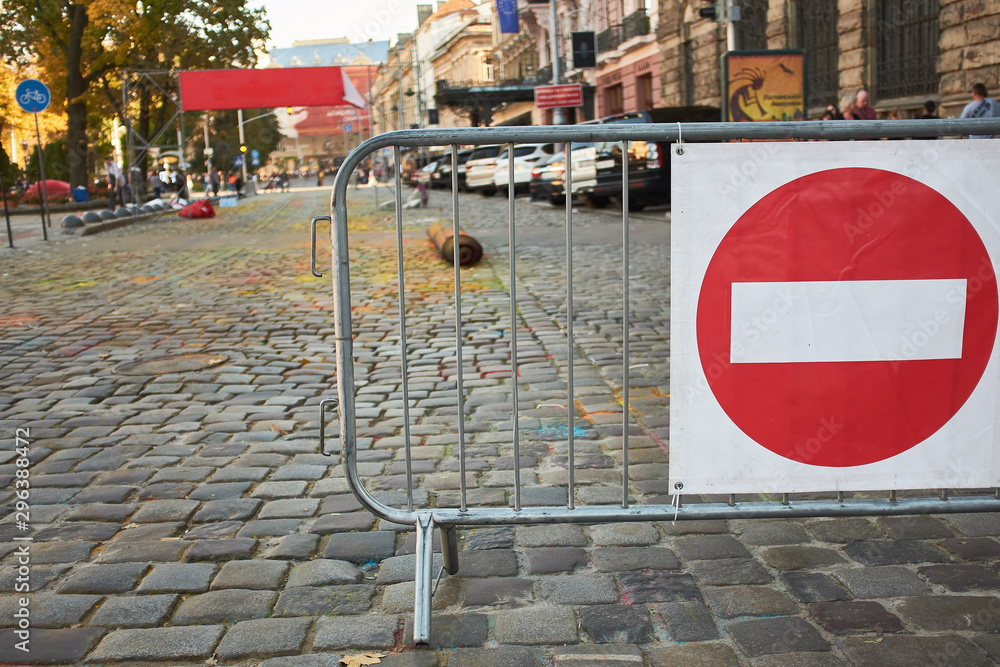 Stop sign hanging on a metal fence. In the frame you can see a ...