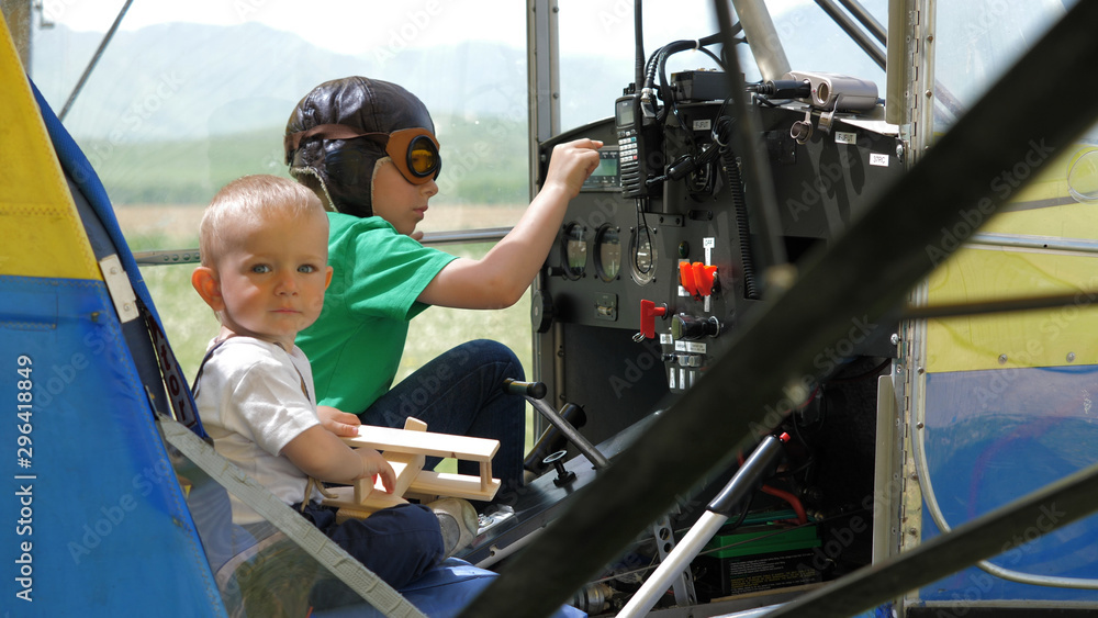 Brothers on board the plane, baby holding a toy, bigger child with ...