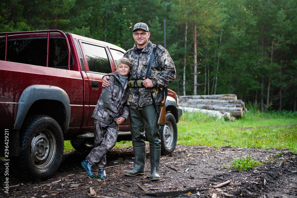 Father and son came to the forest for hunting together. Standing with a ...