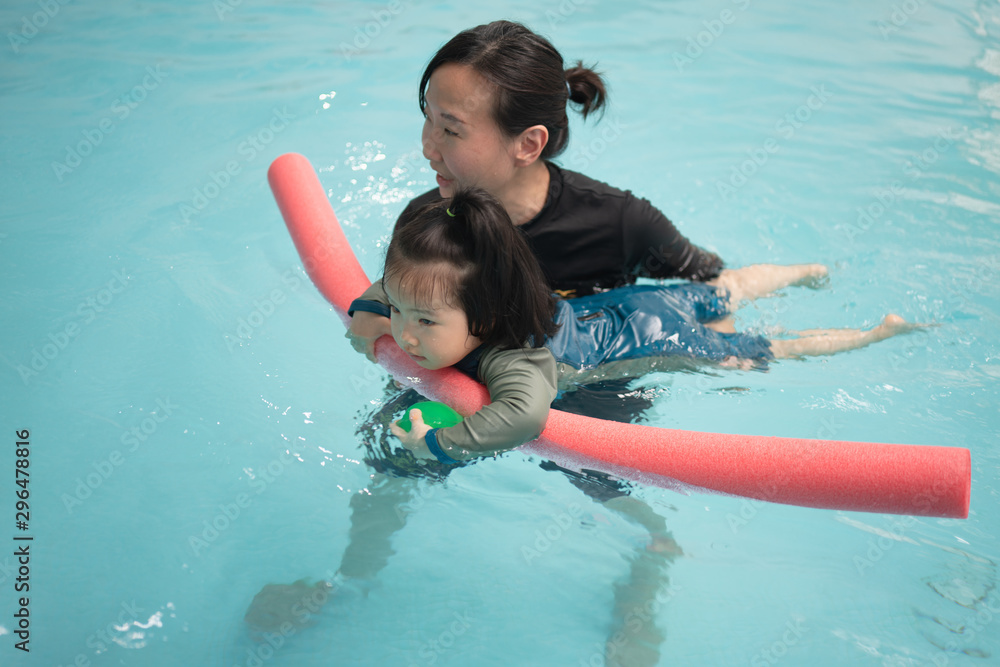 Asian mother learning and enjoy swimming lessons with an adorable 2 ...