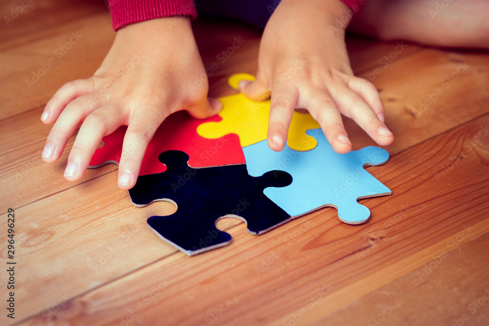 Close up: An autistic child's hands playing a puzzle symbol of Public ...
