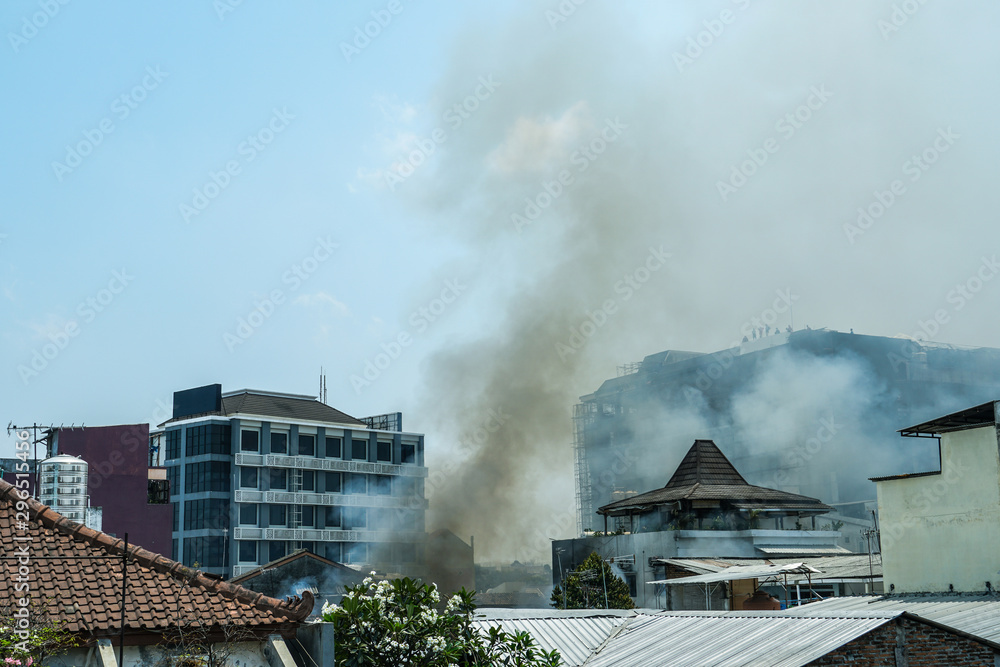 Burning fire flame with smoke on the apartment house roof in the city ...