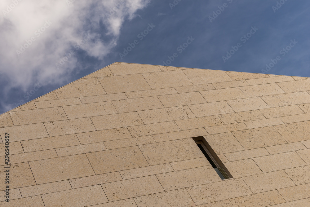 house with stone facadeand a small window view with the blue sky above ...