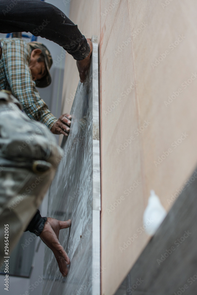 laying marble on wall, installing marble in construction site. Stock ...
