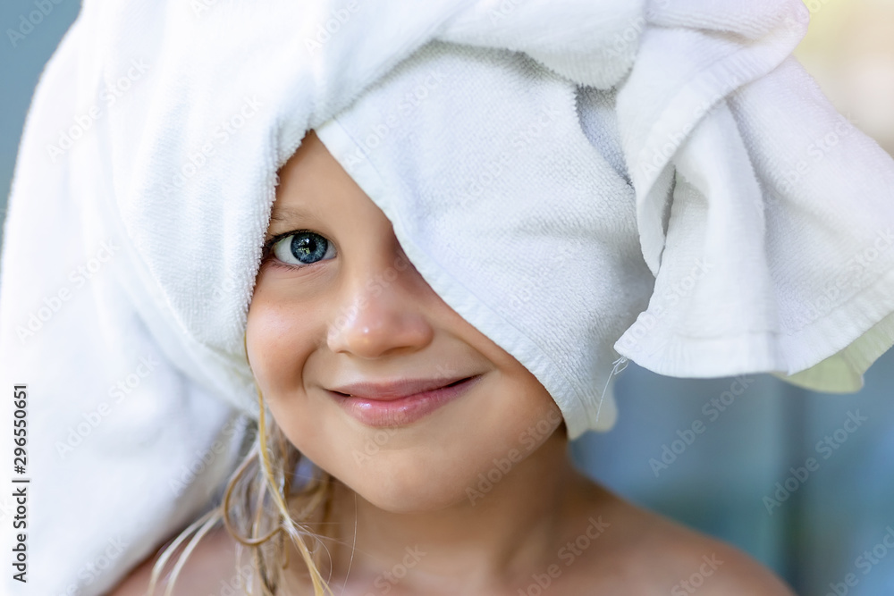 Cute adorable caucasian little blond girl wearing white towel on we ...