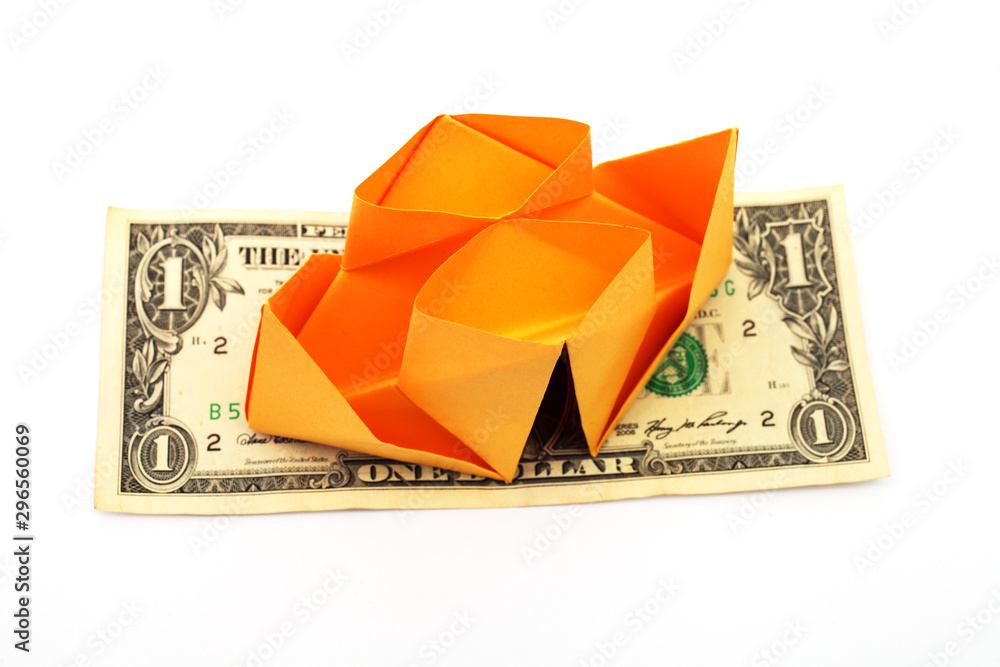 Origami yellow paper steamer, stands on a one-dollar bill, white ...