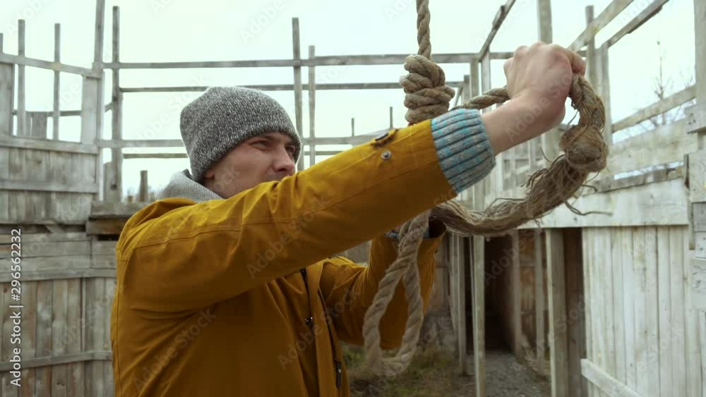 Executioner prepares gallow for execution closeup spinning rope in neck ...