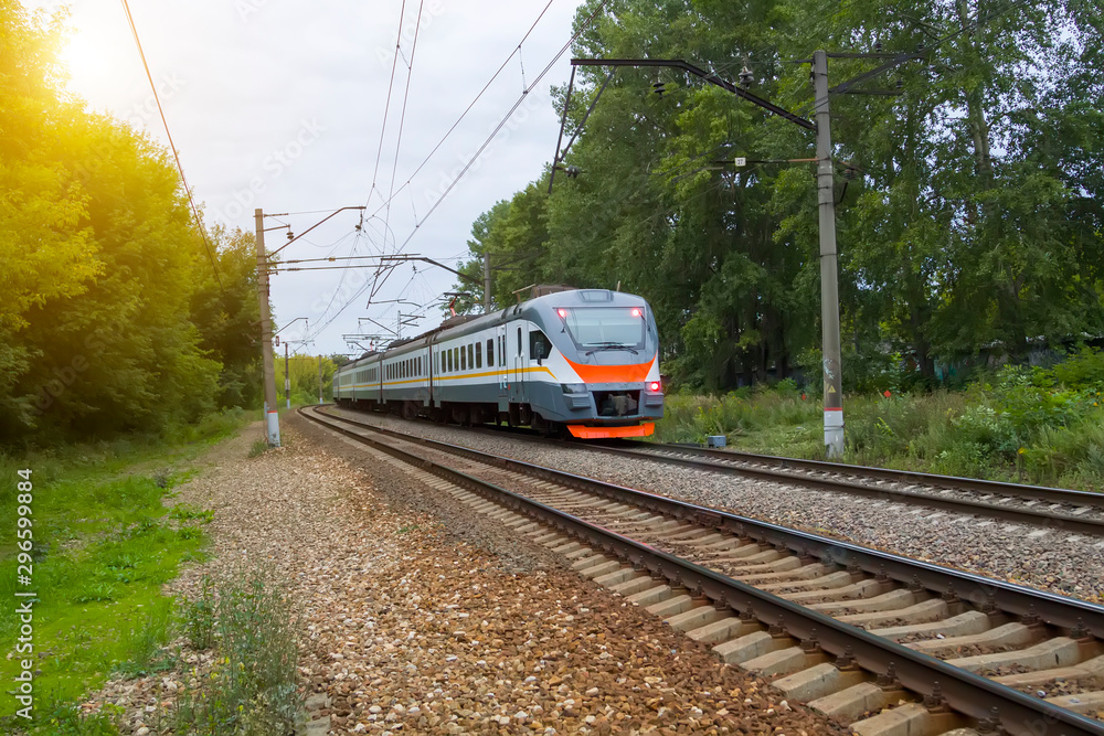 Poster commuter train rides on railway tracks in city with green trees ...