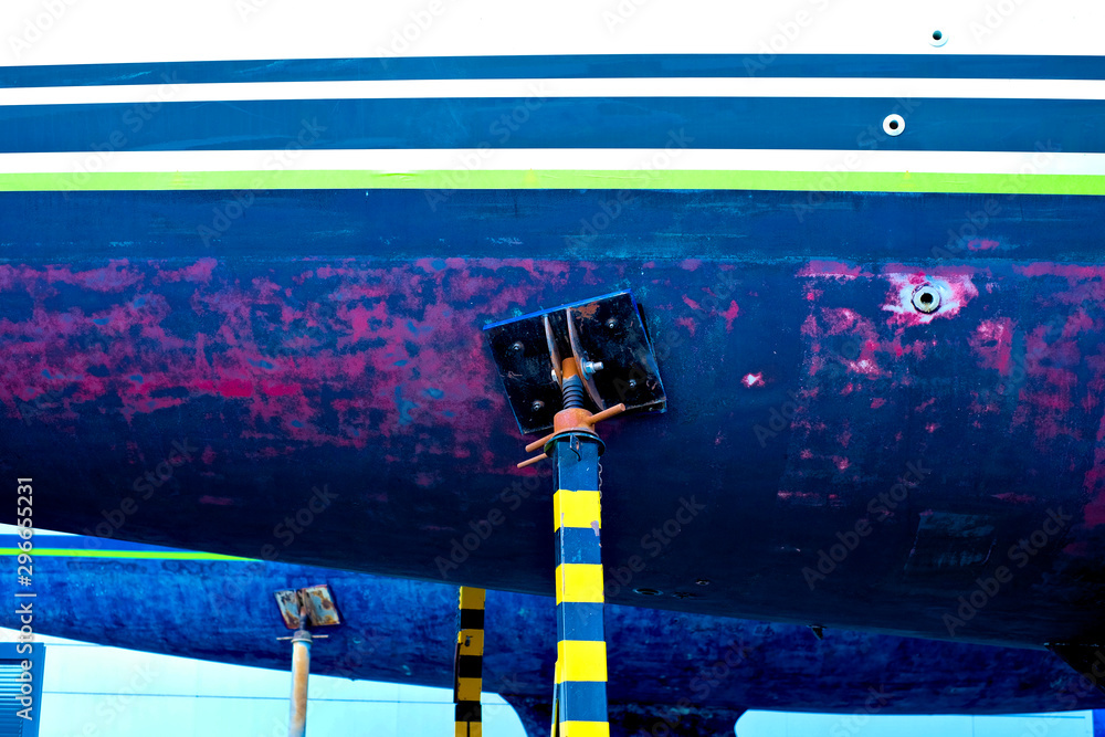 Boatyard works on topsides with hull windows and bottom of a hull of a ...