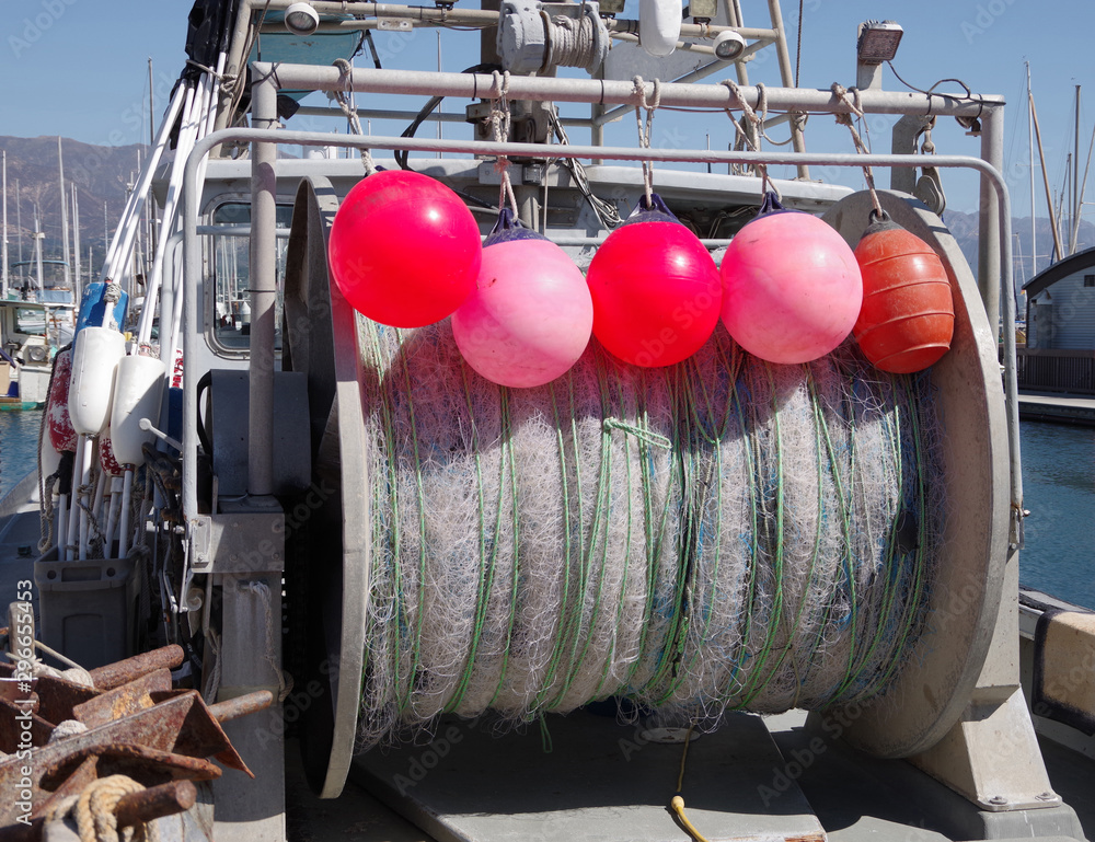 Rolled up fishing net and red and pink buoys on a fishing trawler Stock ...